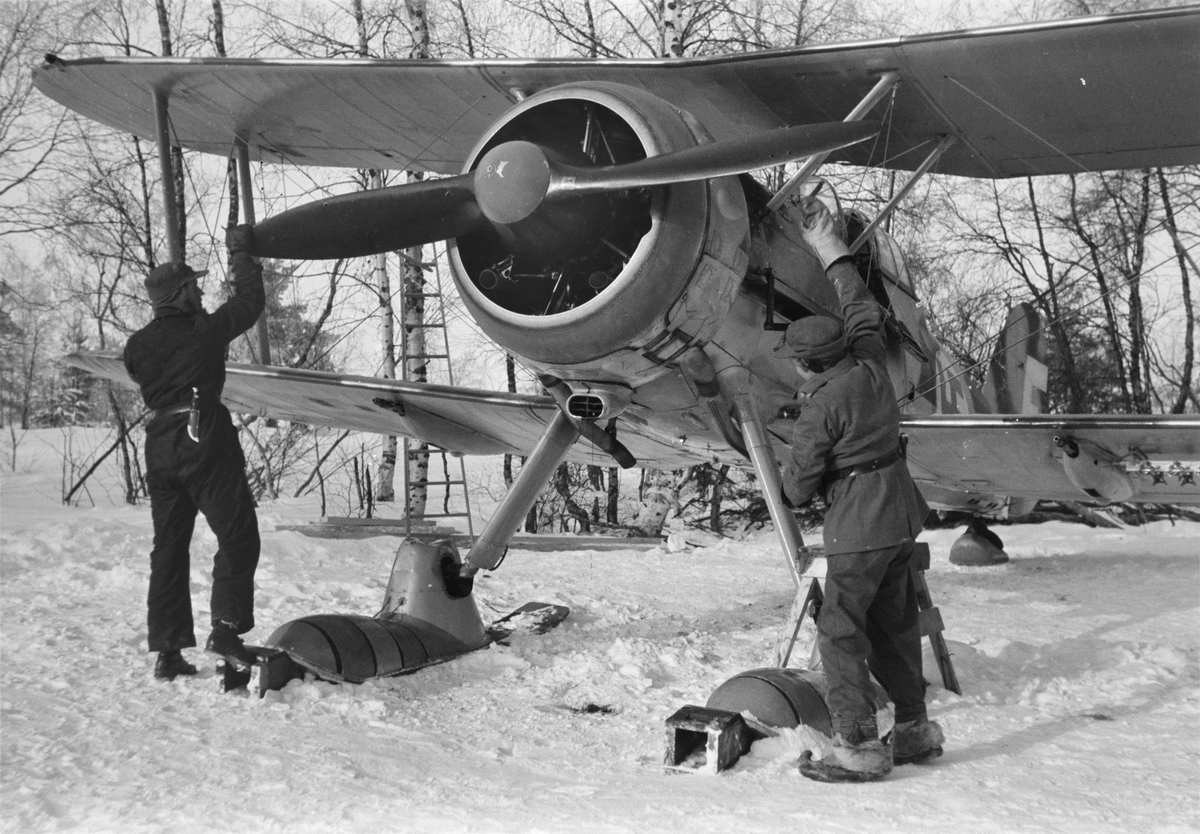 Flygplan Gloster Gladiator gul F görs klart för start. Två mekaniker i ...
